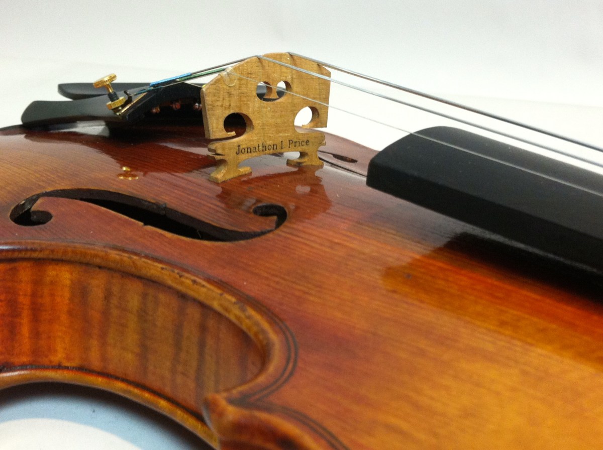 Checking over a setup on a violin, viola, and cello – AD Bows, LLC